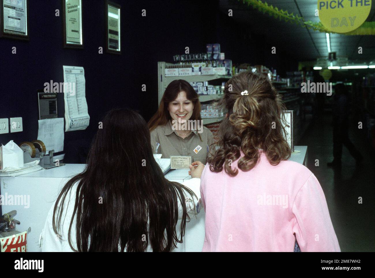 Lucette Falcon, a dependent wife, checks identification cards at the ...