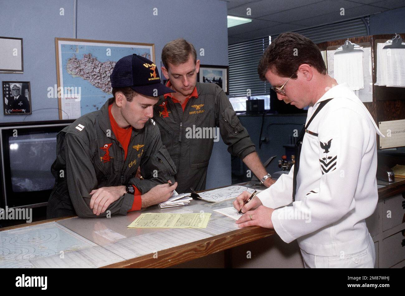 Aerographer's Mate 1ST Class James May briefs two officers of Air Anti ...