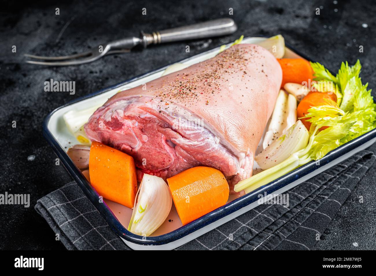 Cooking of Schweinshaxe from Raw pork shank knuckle with vegetables and ...