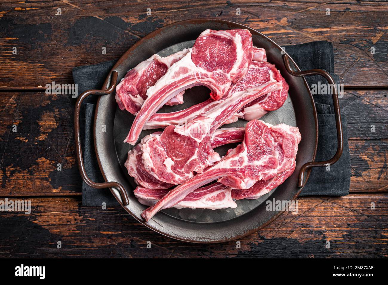 Raw lamb mutton chop steaks, fresh meat cutlets on butcher table. Black ...