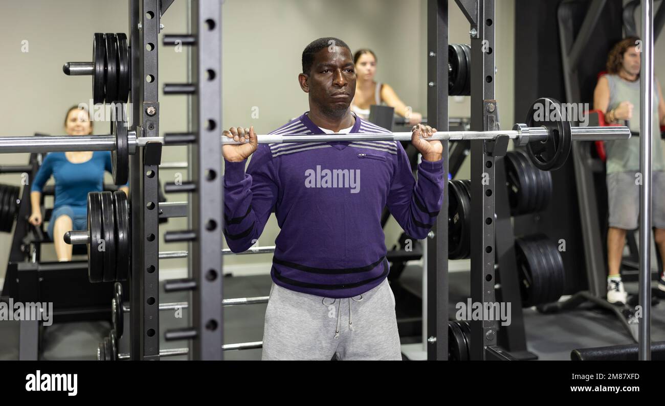 African american man doing barbell squats in gym Stock Photo - Alamy