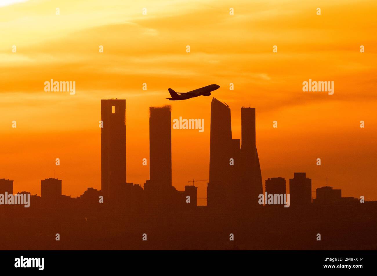 Madrid, Spain. 12th Jan, 2023. The sun silhouettes a plane as it flies ...