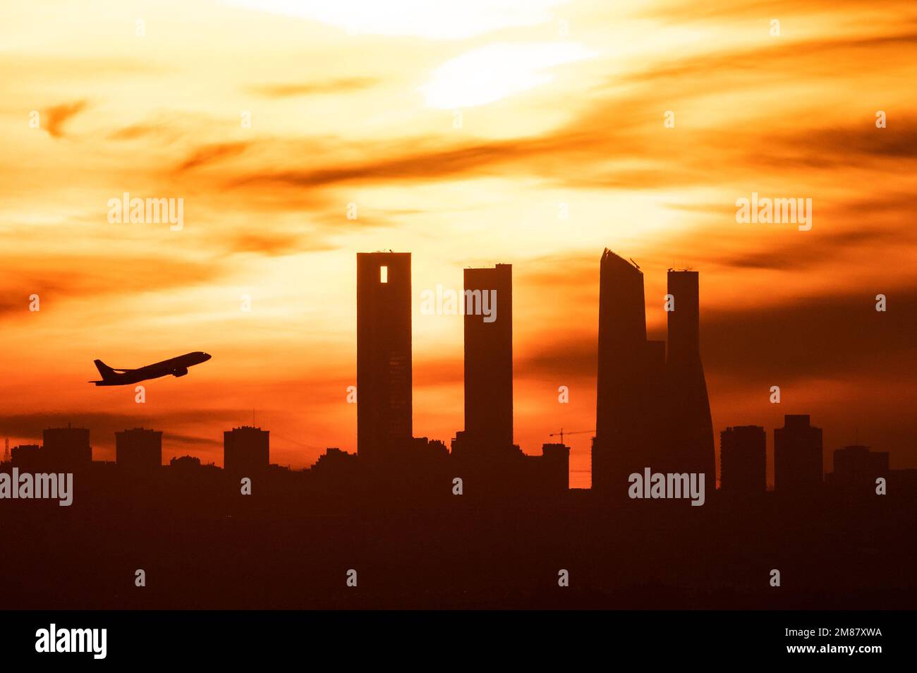 Madrid, Spain. 12th Jan, 2023. The sun silhouettes a plane as it flies ...