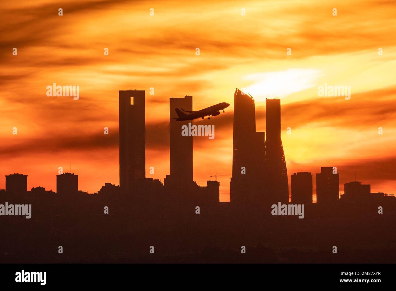 Madrid, Spain. 12th Jan, 2023. The sun silhouettes a plane as it flies ...