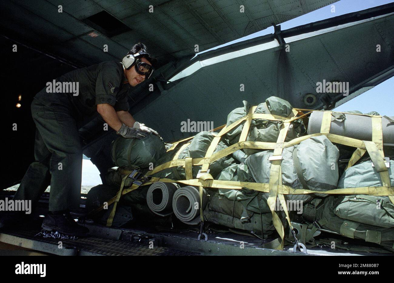 An Air Force sergeant pushes a pallet of field equipment down a loading ...