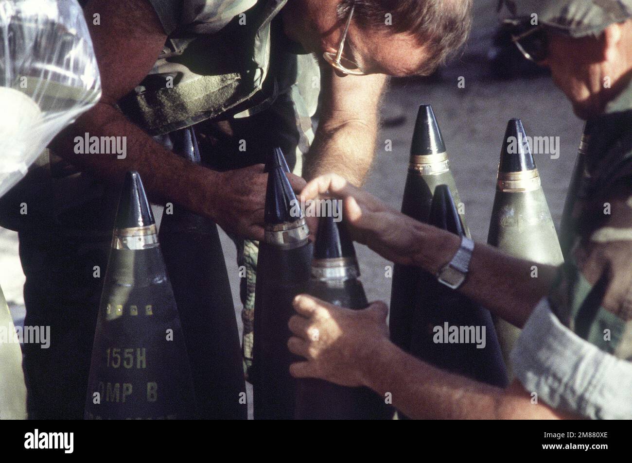 Marines quickly secure fuses on 155mm howitzer projectiles during a ...