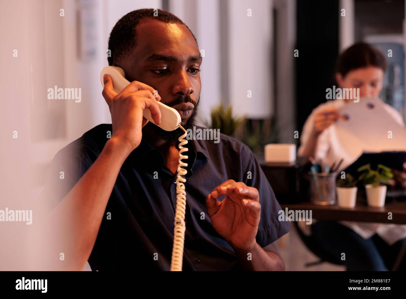 Project manager discussing startup strategy plan on landline phone ...