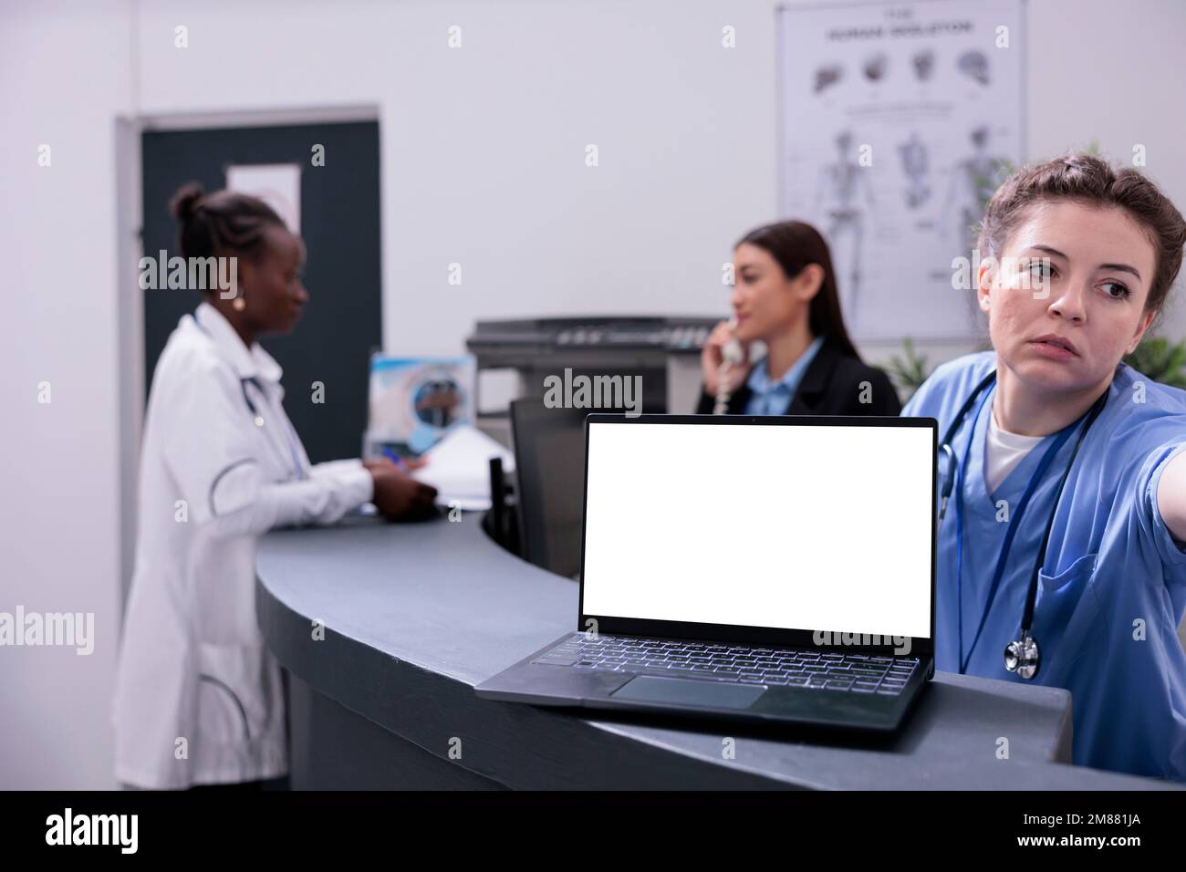 Laptop computer with white isolated screen standing on hospital counter ...