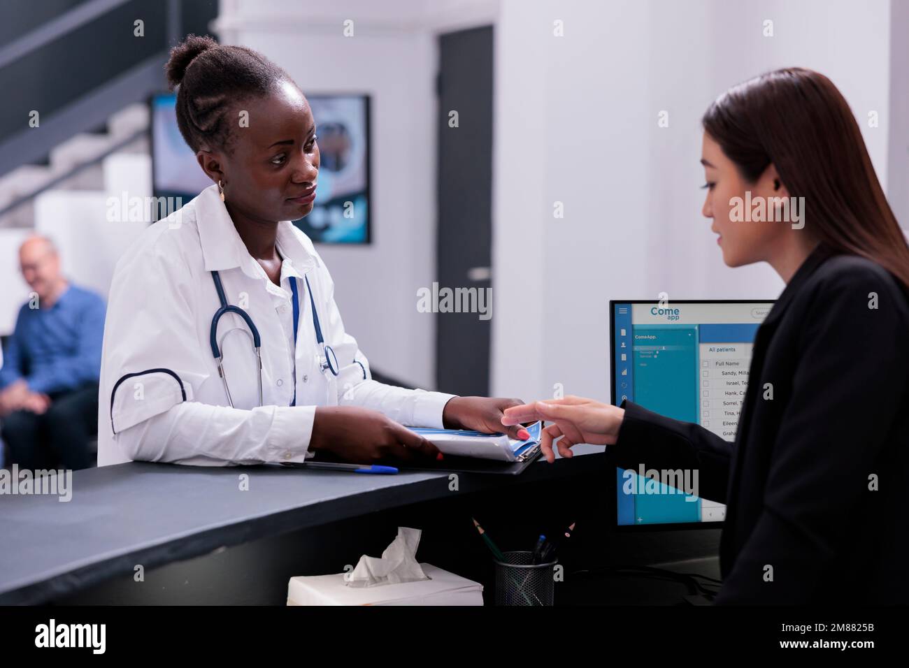 Receptionist helping physician doctor with checkup visit appointments ... Receptionist helping physician doctor with checkup visit appointments ...