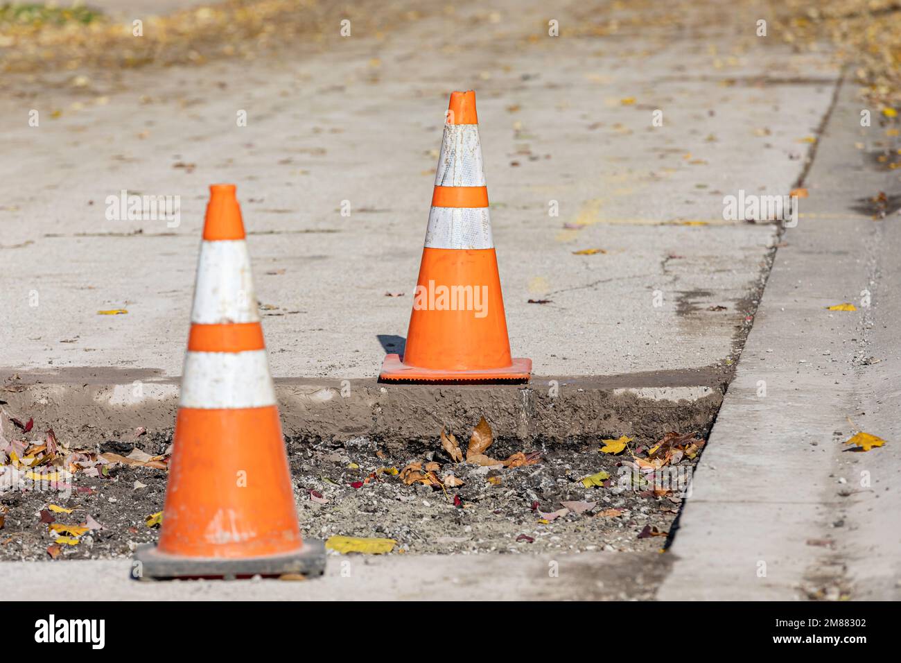 City street repair with orange traffic cones. Road construction ...