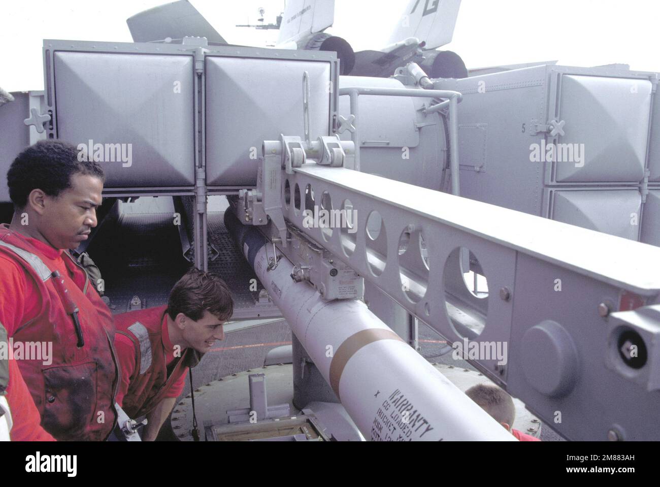 Ordnancemen check the position of an RIM-7 Sea Sparrow missile being ...