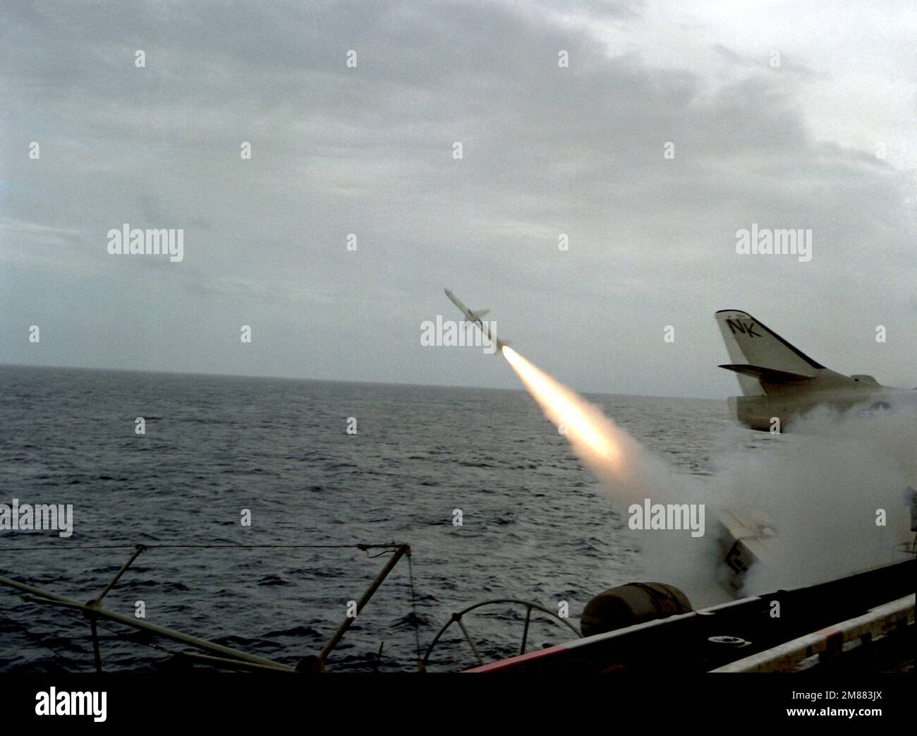 A RIM-7 Sea Sparrow missile is launched from the starboard side forward ...