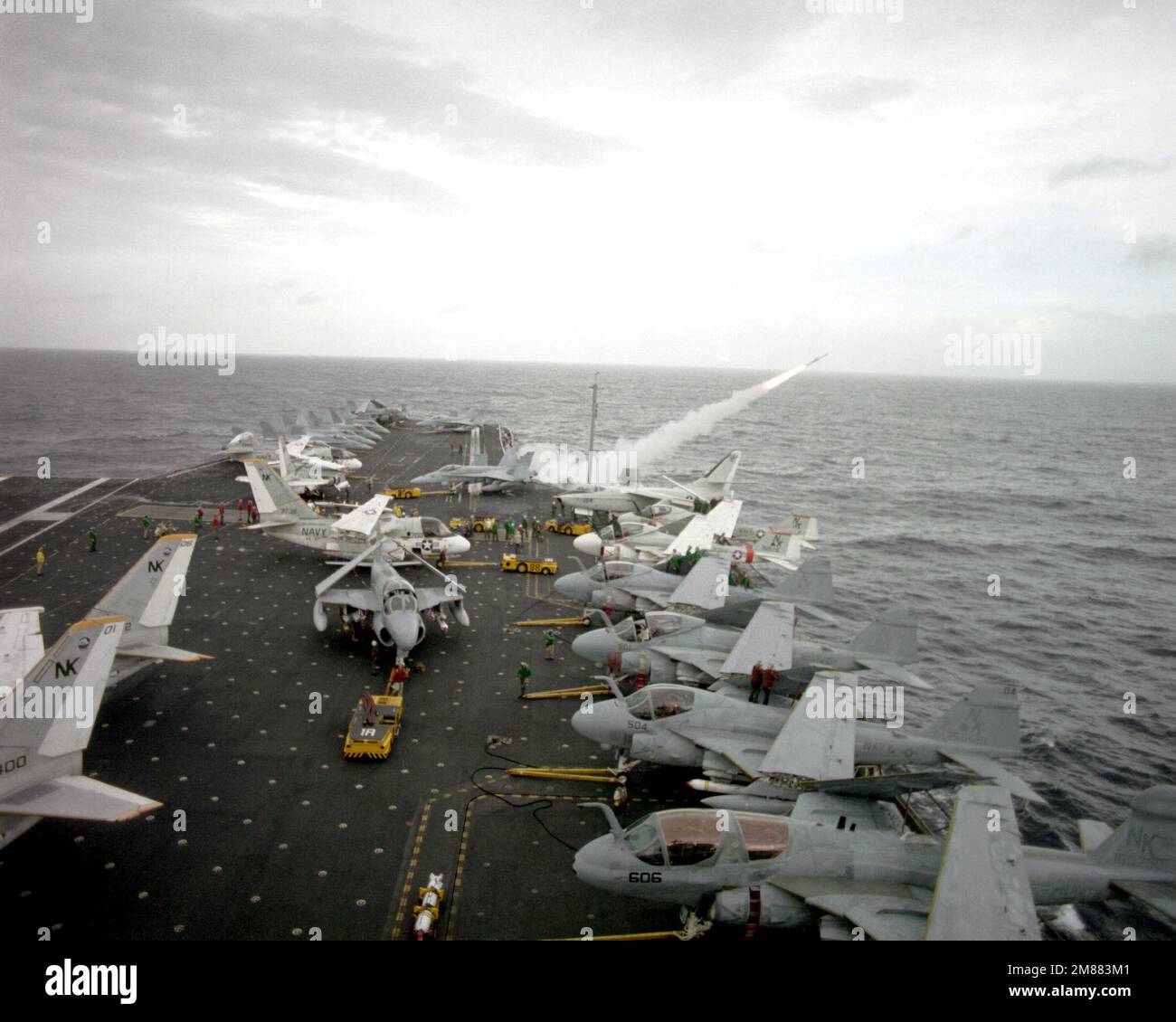 A RIM-7 Sea Sparrow missile is launched from the starboard side forward ...