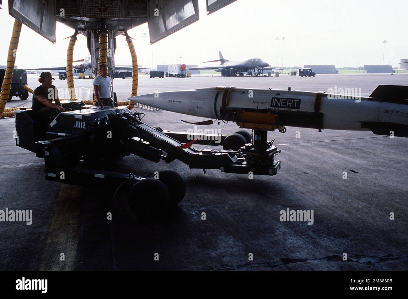 Members of the 96th Munitions Maintenance Squadron use a weapons loader ...