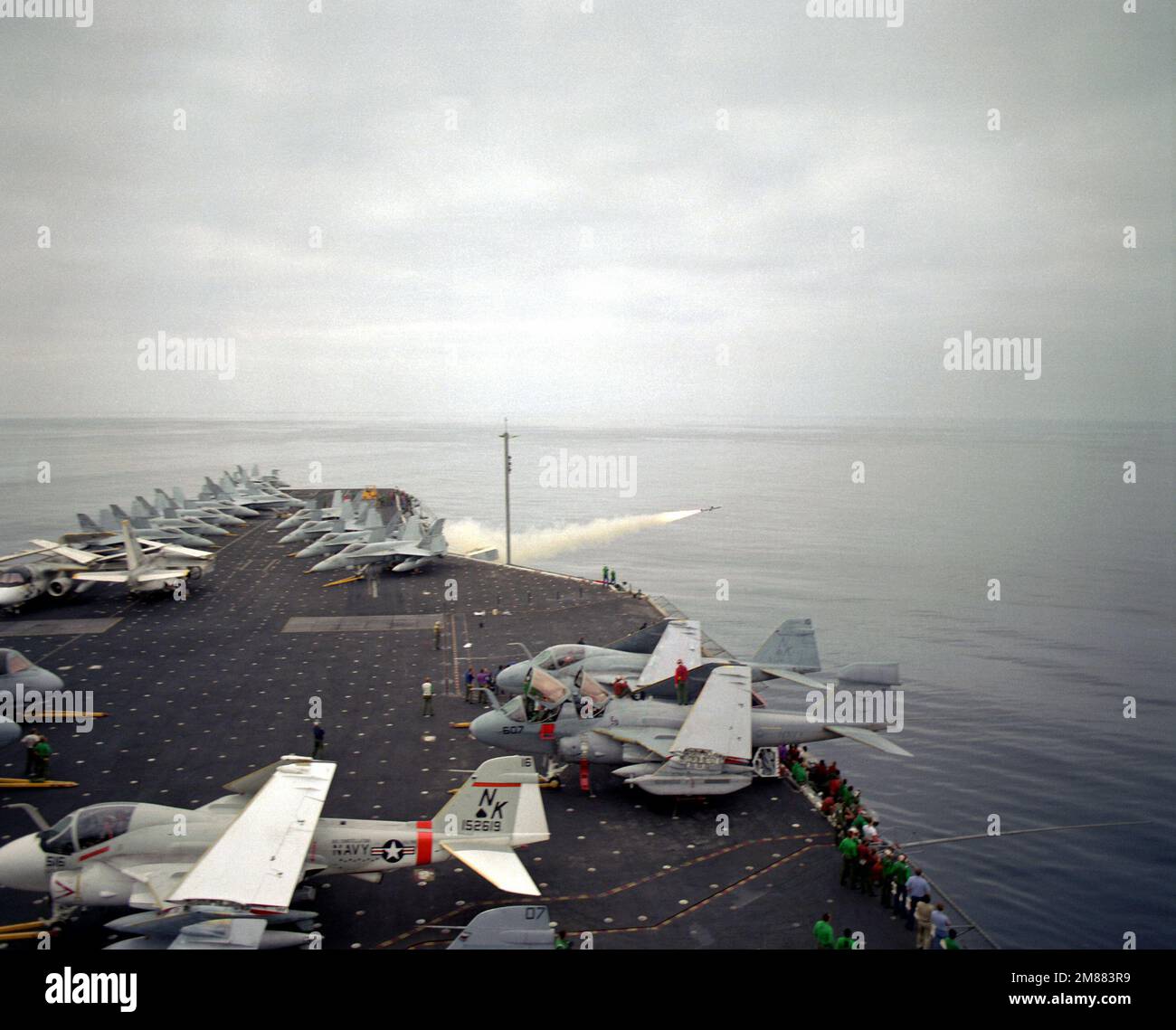 A RIM-7 Sea Sparrow missile is launched from the starboard side forward ...