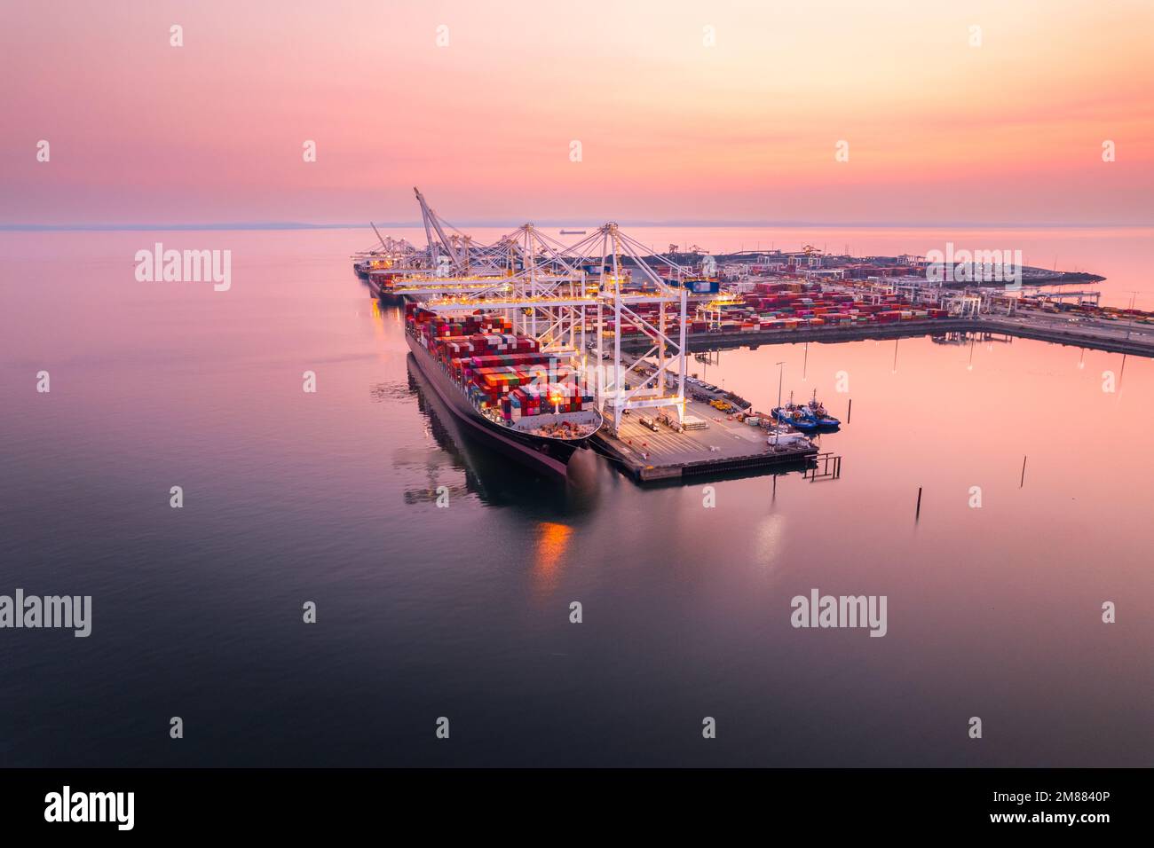 Cargo terminal loading shipping containers onto cargo ships, aerial footage, hyperlapse ...