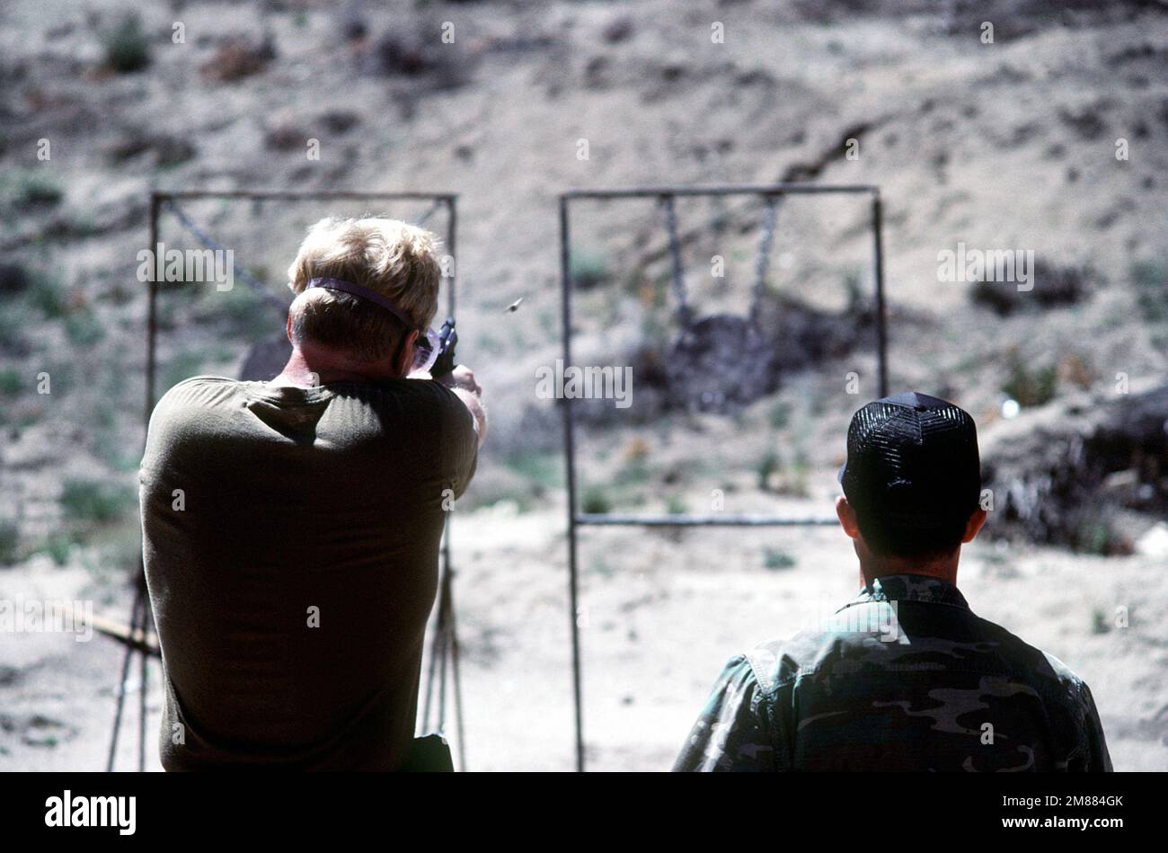 A trainee fires at a target on the pistol range during Basic Underwater ...