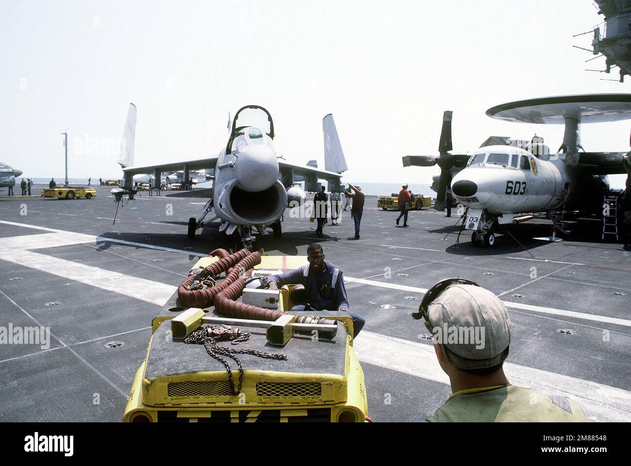 An MD-3A tow tractor is used to tow an A-7E Corsair II aircraft to a ...