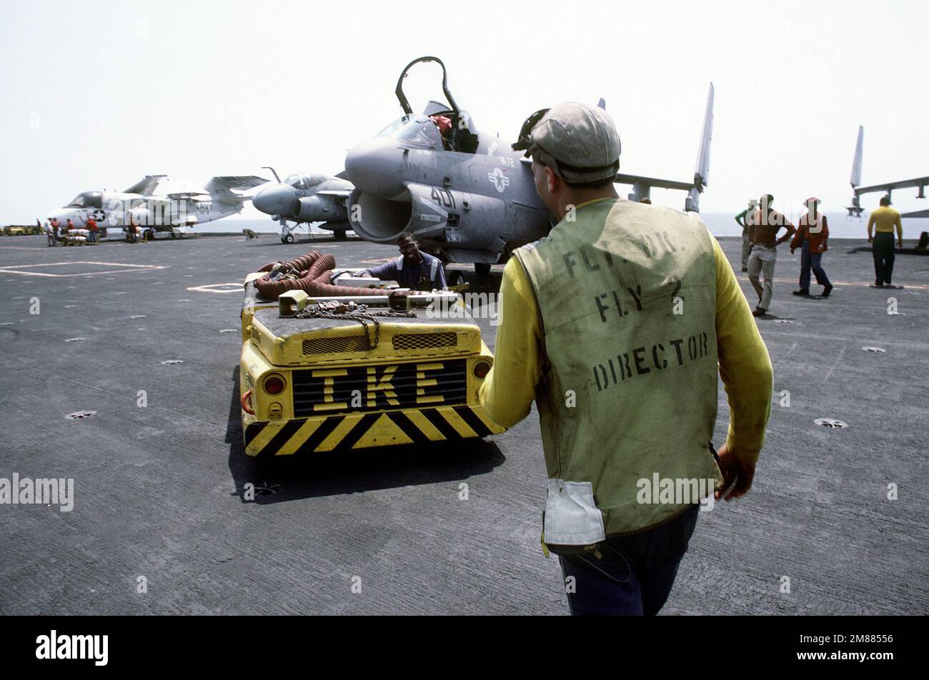 An MD-3A tow tractor is used to tow an A-7E Corsair II aircraft to a ...