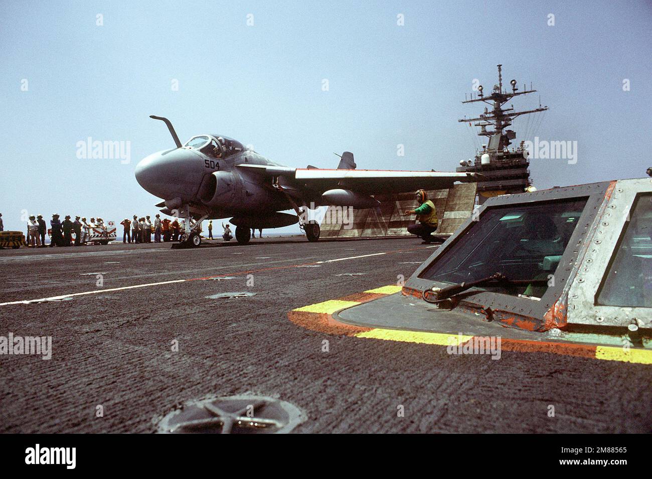 A safety observer signals instructions to an A-6E Intruder pilot during ...