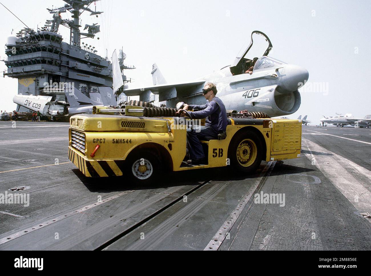 An MD-3A tow tractor is used to tow an Attack Squadron 72 (VA-72) A-7E ...