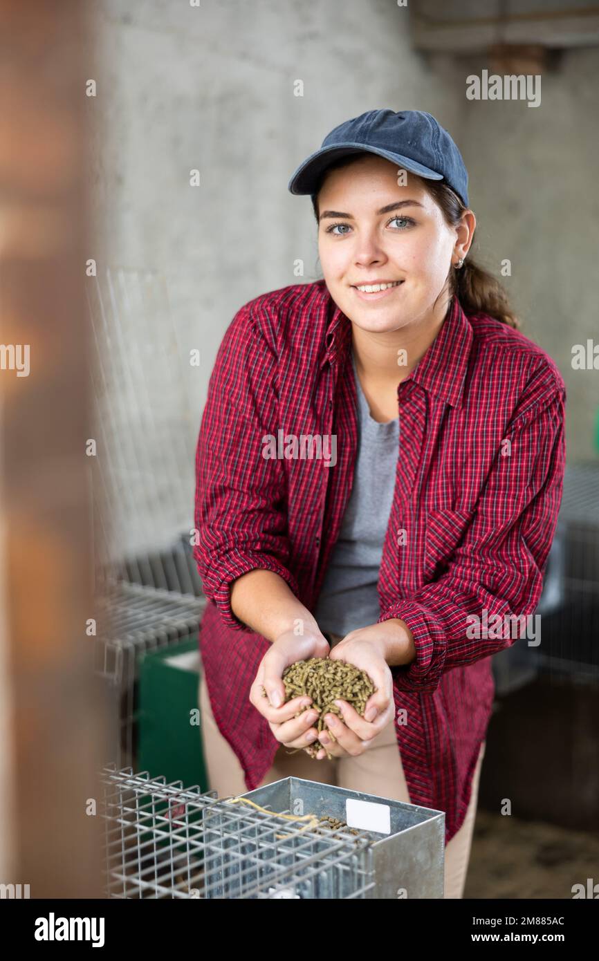 worker showing feed for animal in her hands Stock Photo - Alamy