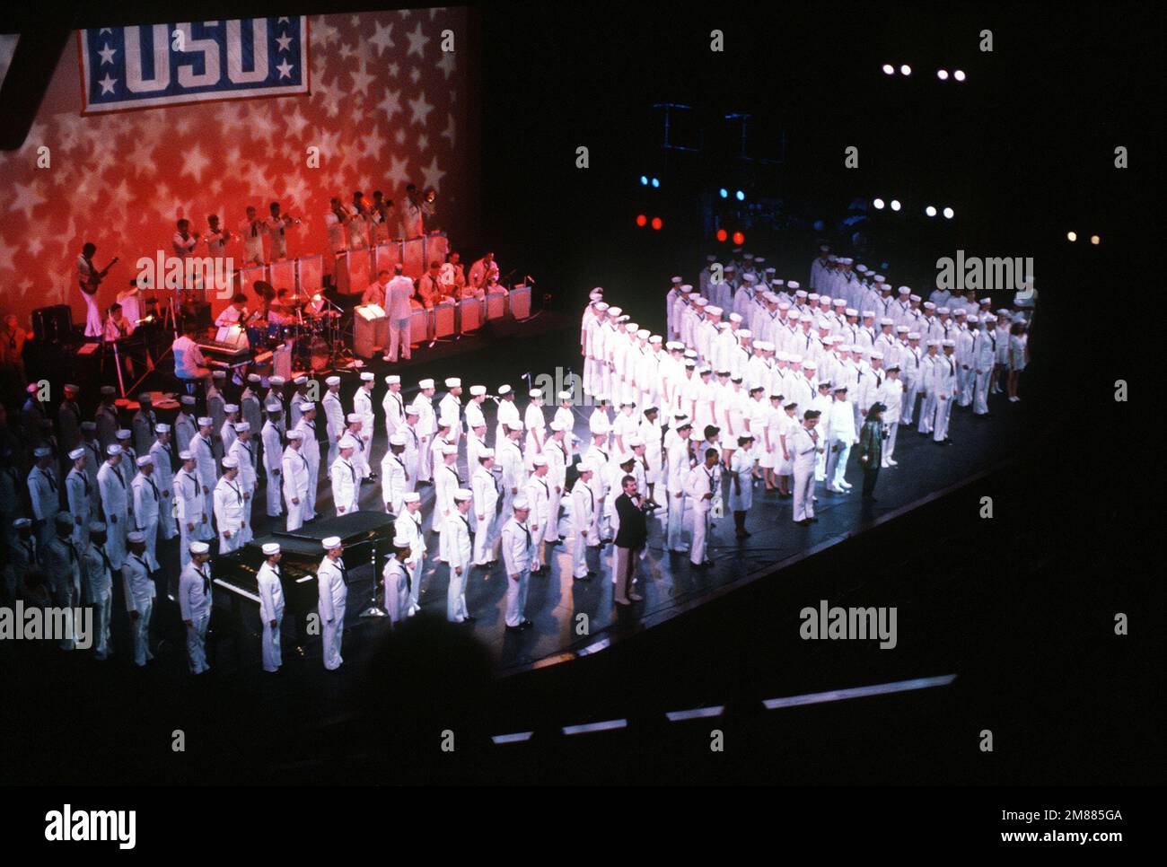U.S. Navy personnel gather onstage for a musical number featuring ...