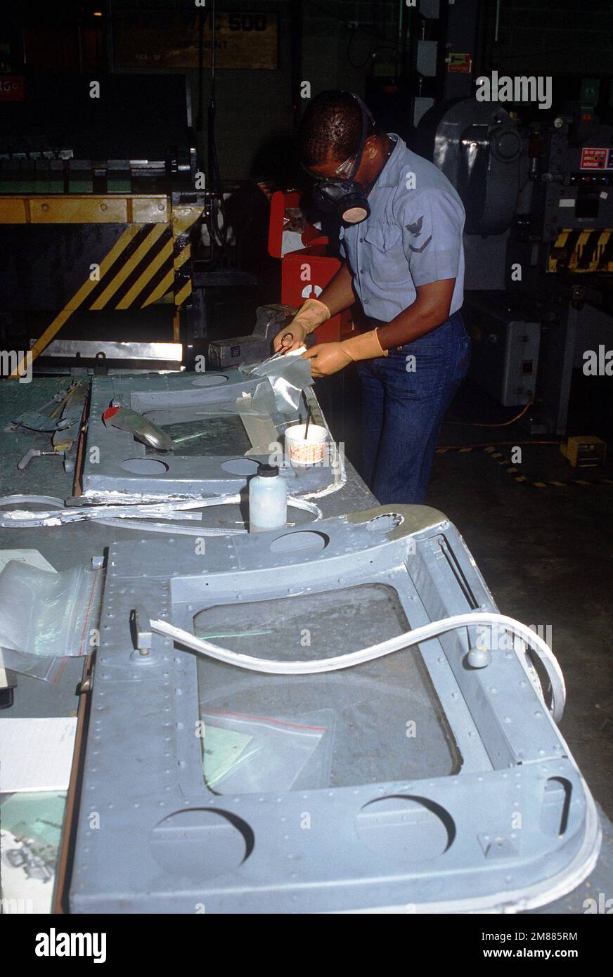 Aviation Structual Mechanic S (Structures) 3rd Class L. Bedford cuts a section of fiberglass to ...