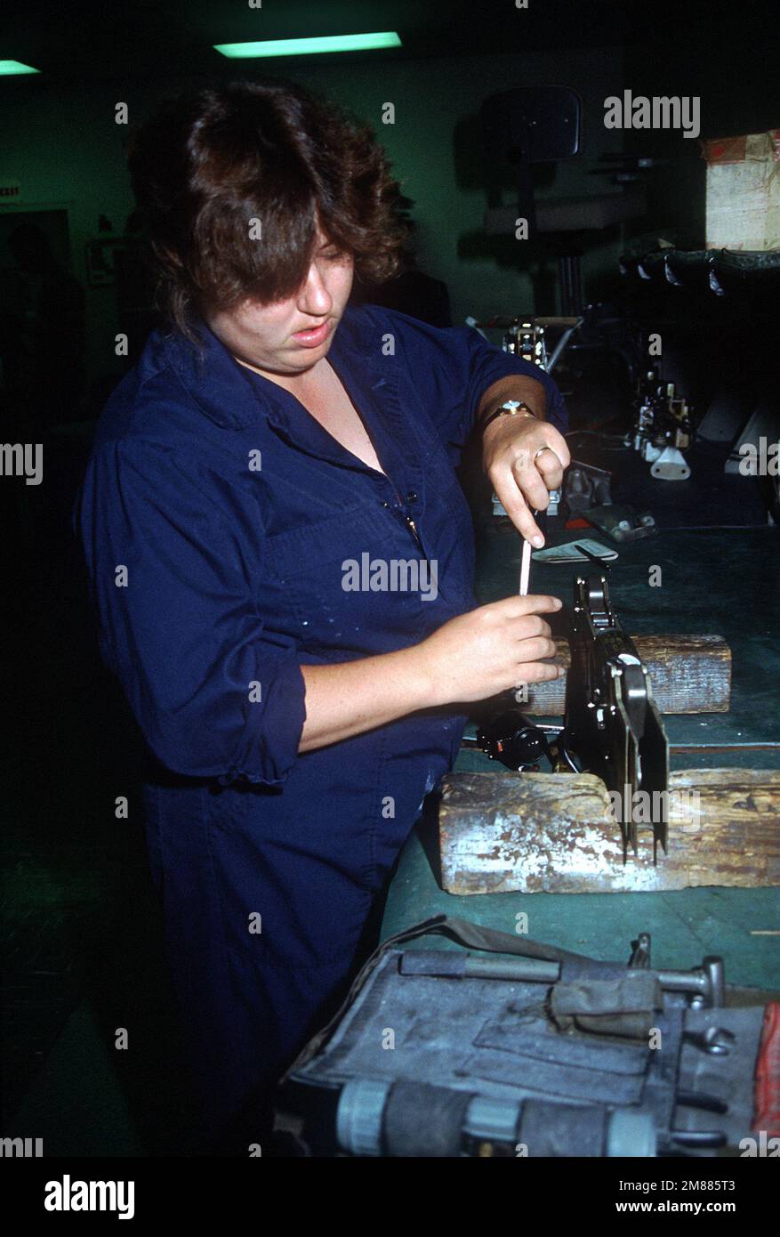 Aviation Ordnanceman M. Delrio repairs a bomb release unit in an ...