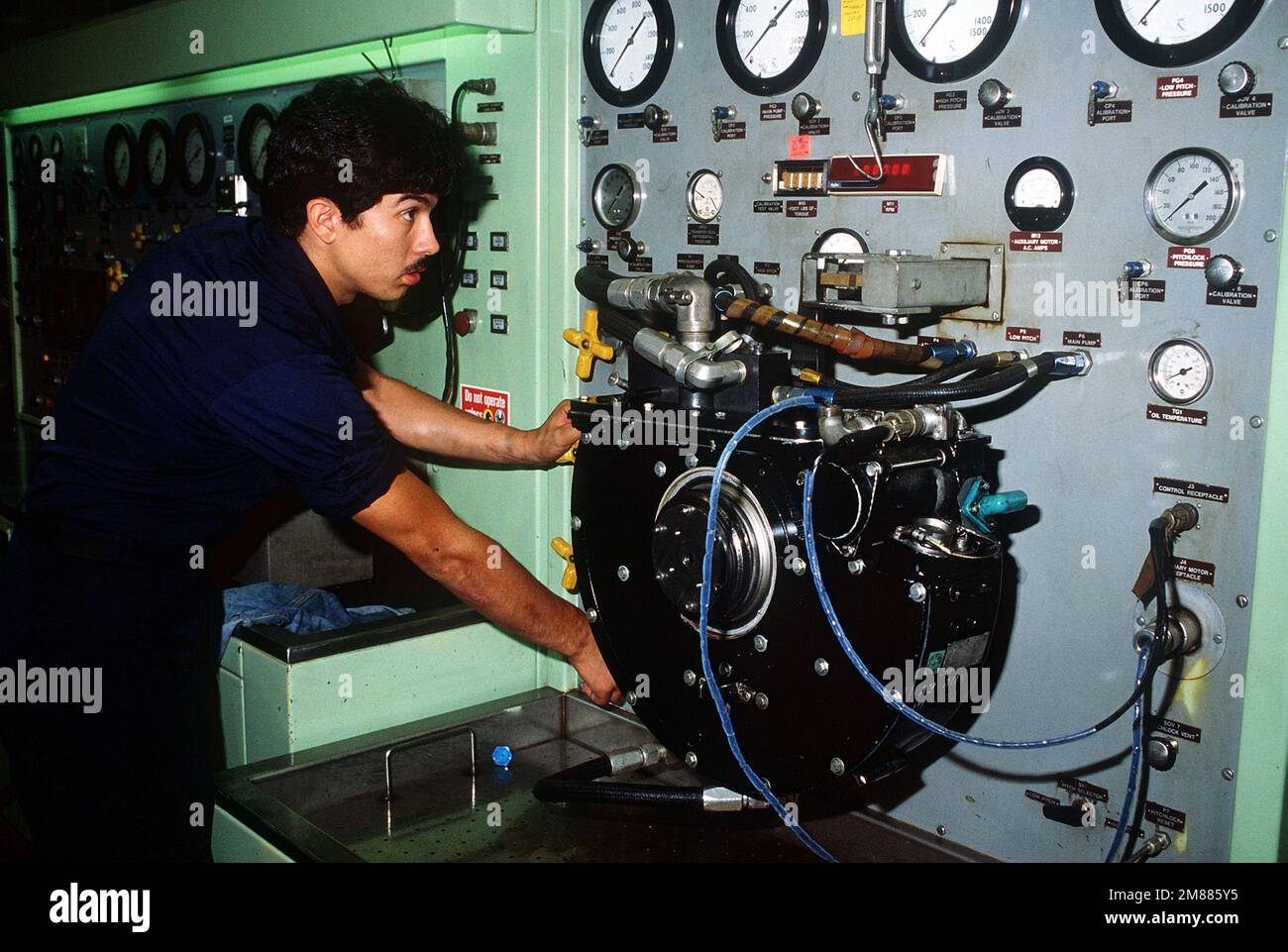Aviation Machinist's Mate 2nd Class D. Rogers checks a propeller ...