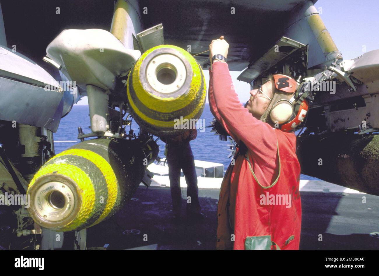 An ordnance crew member from Attack Squadron 165 (VA-165) mounts Mark ...