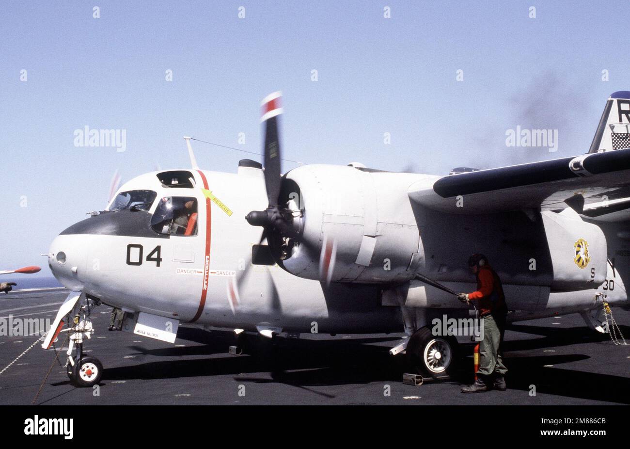 A flight deck crew member stands by with a fire extinguisher as a C-1A ...