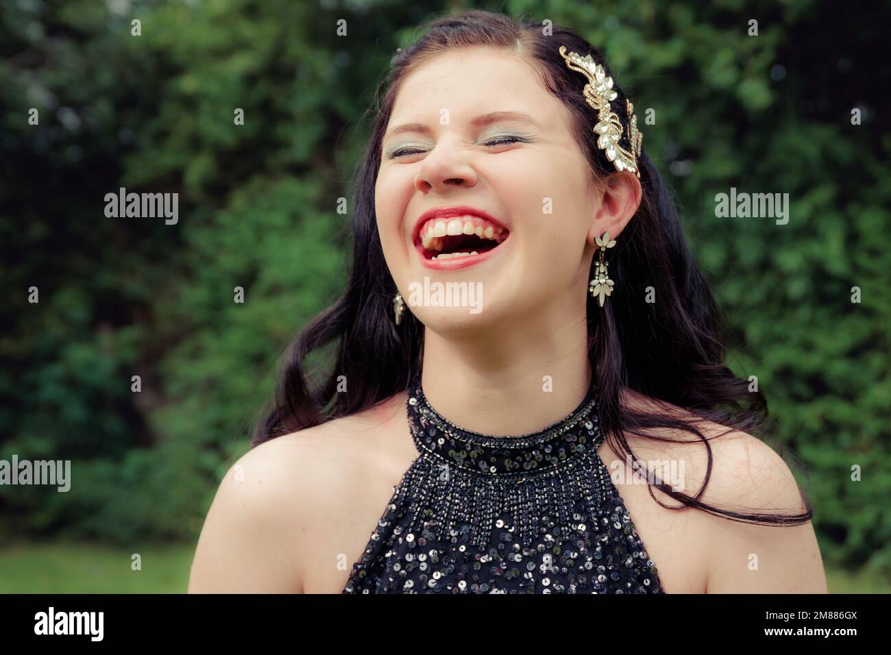 Close up of laughing teenage girl in black sequin racerback prom dress ...