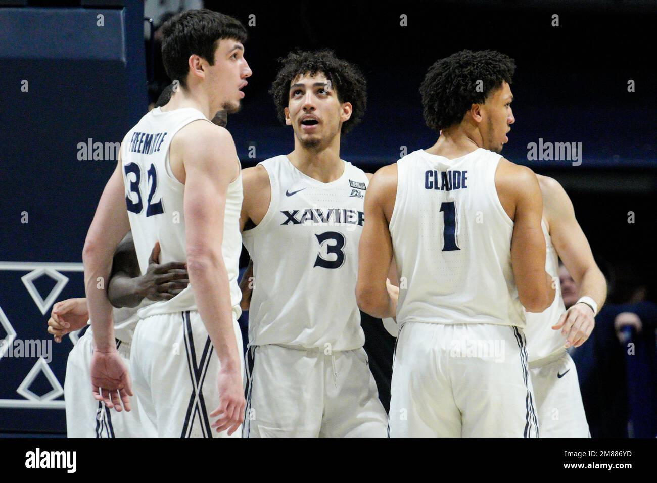 Xavier's Zach Freemantle (32), Colby Jones (3) and Desmond Claude (1) huddle during the second ...