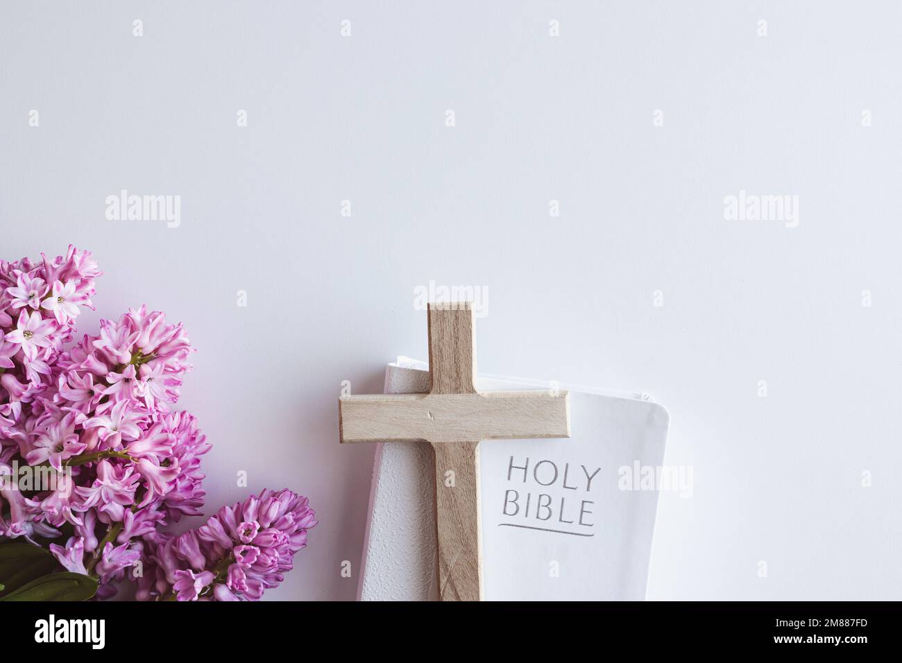 Border of white Holy Christian Bible, small wood cross and bouquet of ...