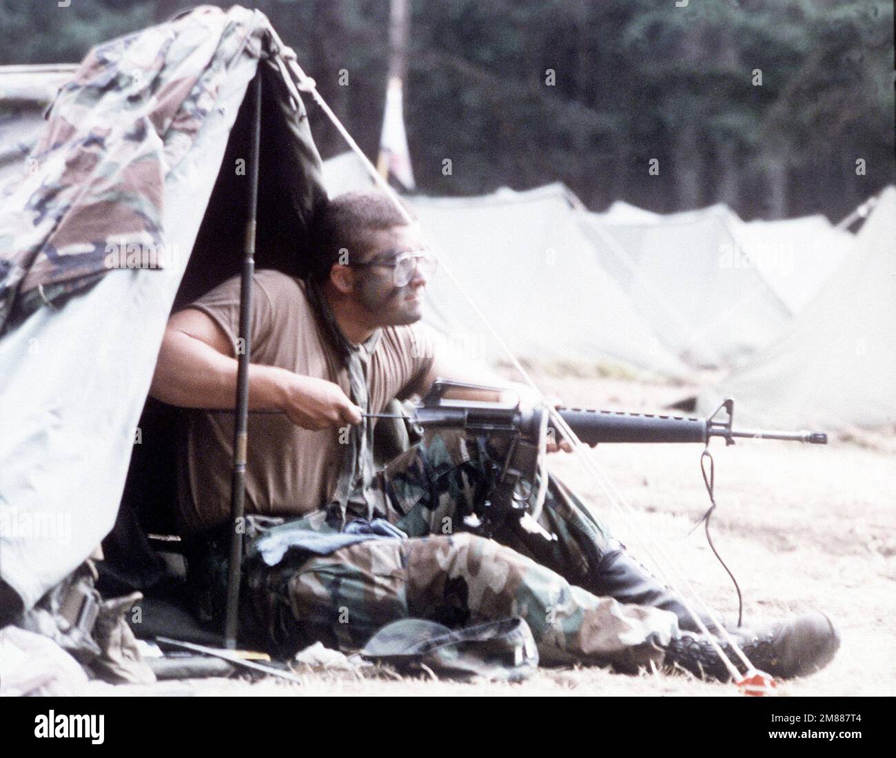 A cadet cleans his M-16A1 rifle in the door of his tent during the 4th ...