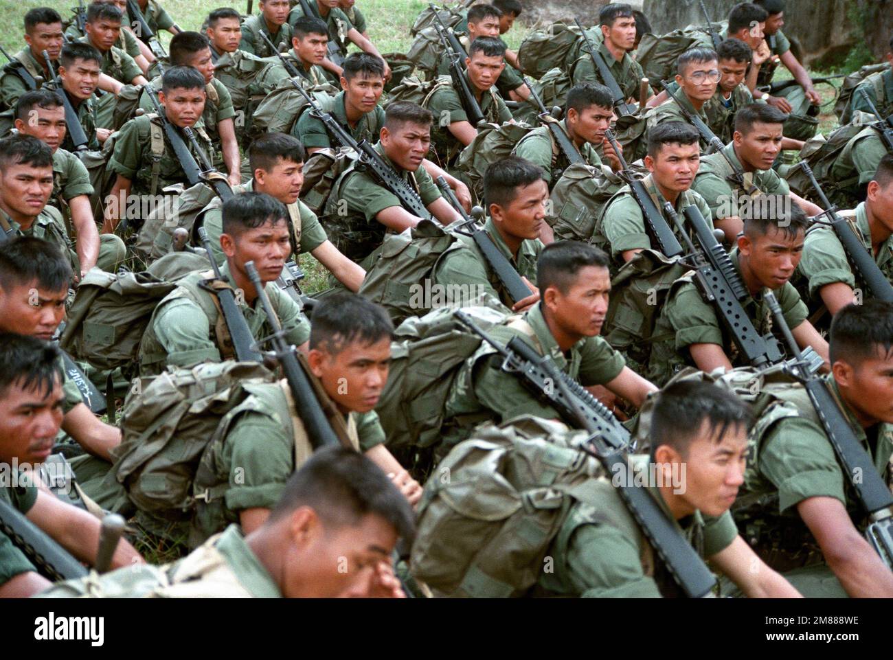 Infantry troops of the Royal Thai Army, armed with M-16 rifles, listen ...