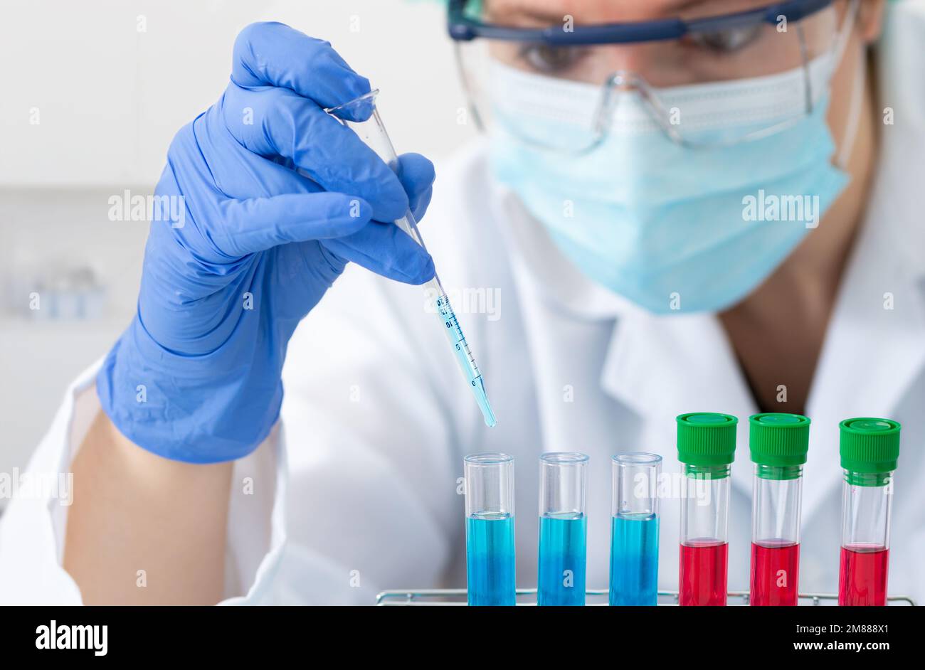 Cropped shot of an attractive young female scientist using a pipette to ...