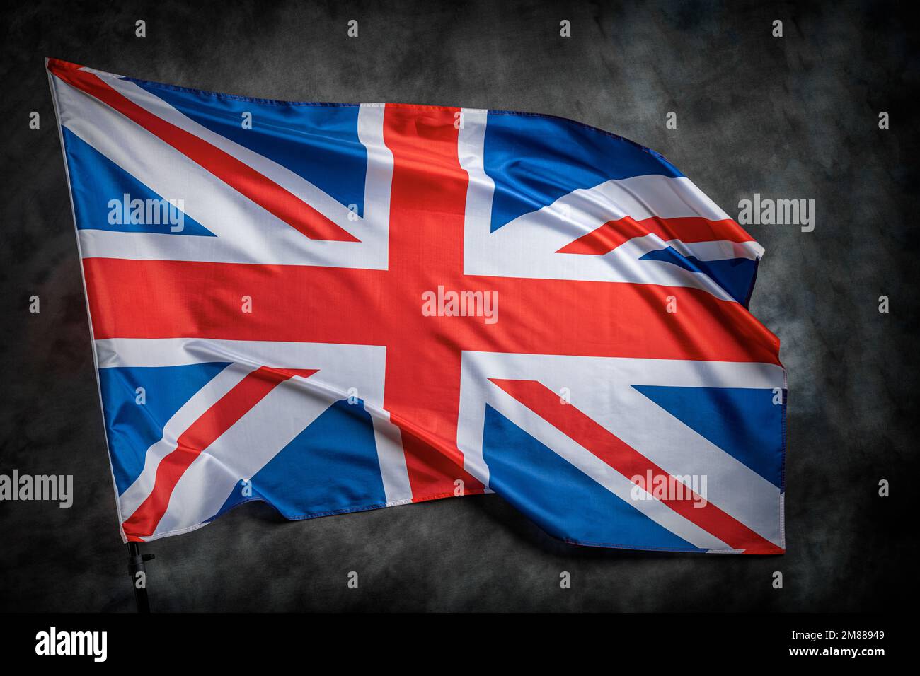 The UK flag waving in the wind against a dark Stock Photo - Alamy
