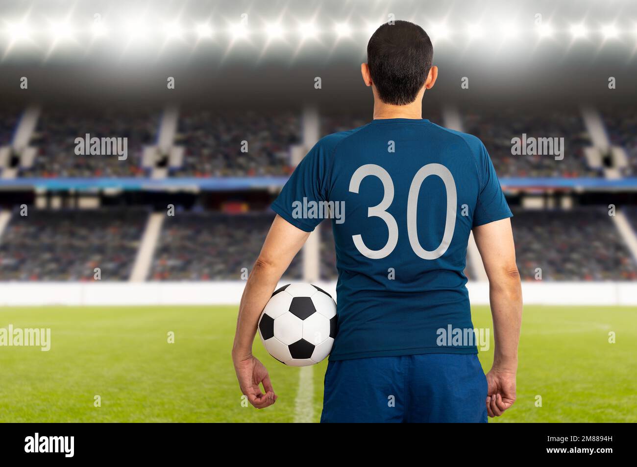 Cropped rearview image of a young player man holding a soccer ball ...