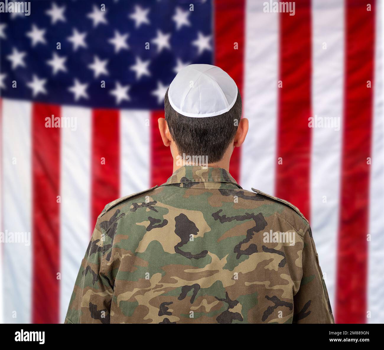 Behind a young soldier with military uniform and kippa on his head ...