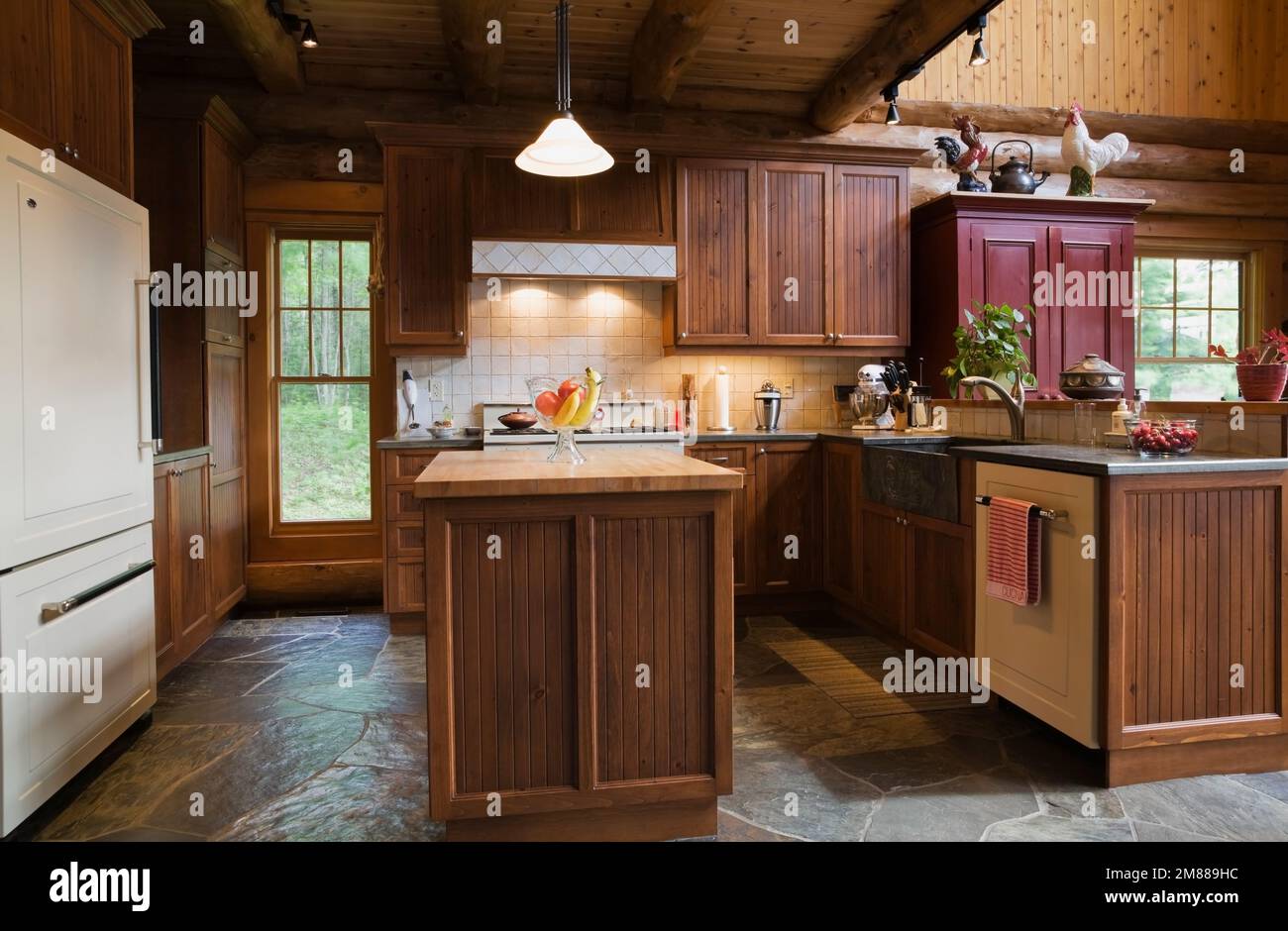 Country style kitchen with island and slate tile floor inside ...