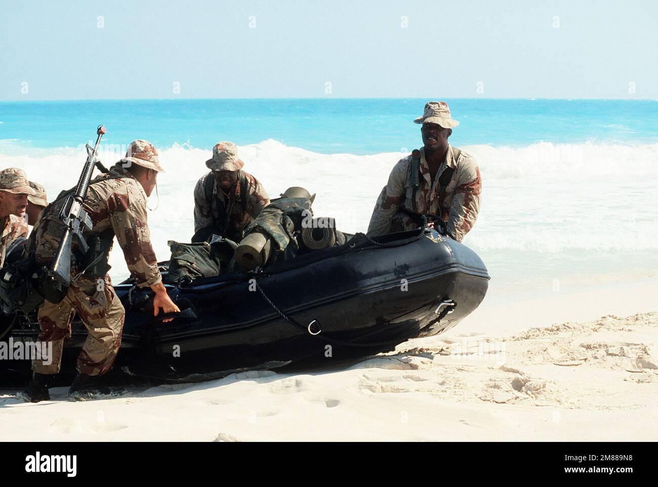 Members of a Marine reconnaissance team come ashore in a Zodiac ...