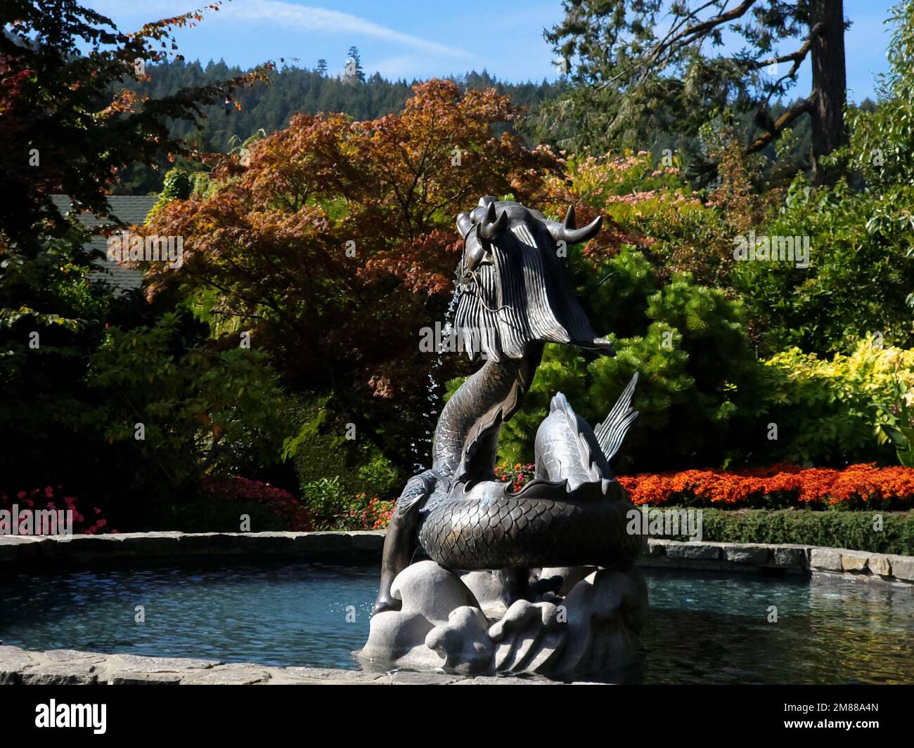 A sculpture of a serpent spitting water into a fountain in a lovely ...