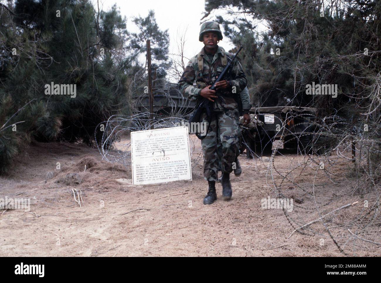 A soldier armed with an M-16A1 rifle patrols a controlled area while ...