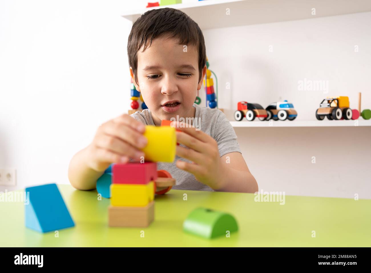Child playing with colourful educational toy blocks on the table at ...
