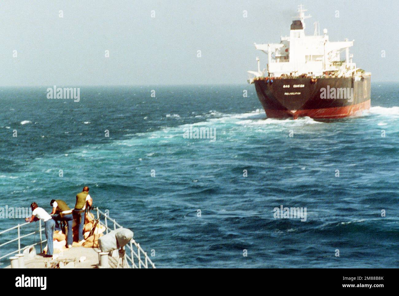 Crew members stand watch on the bow of the guided missile destroyer USS ...