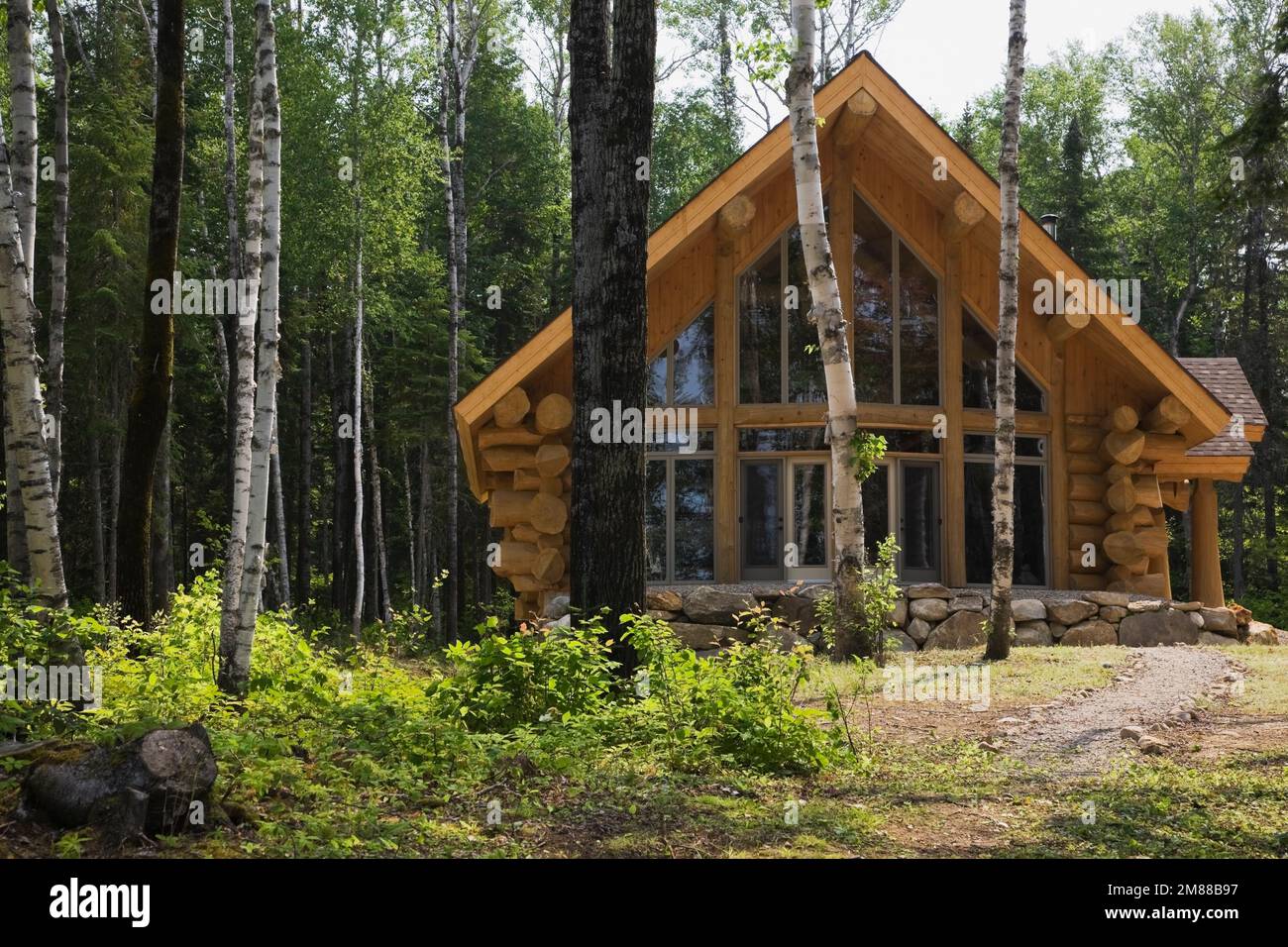 Side view of handcrafted Eastern white pine cottage style log home in ...