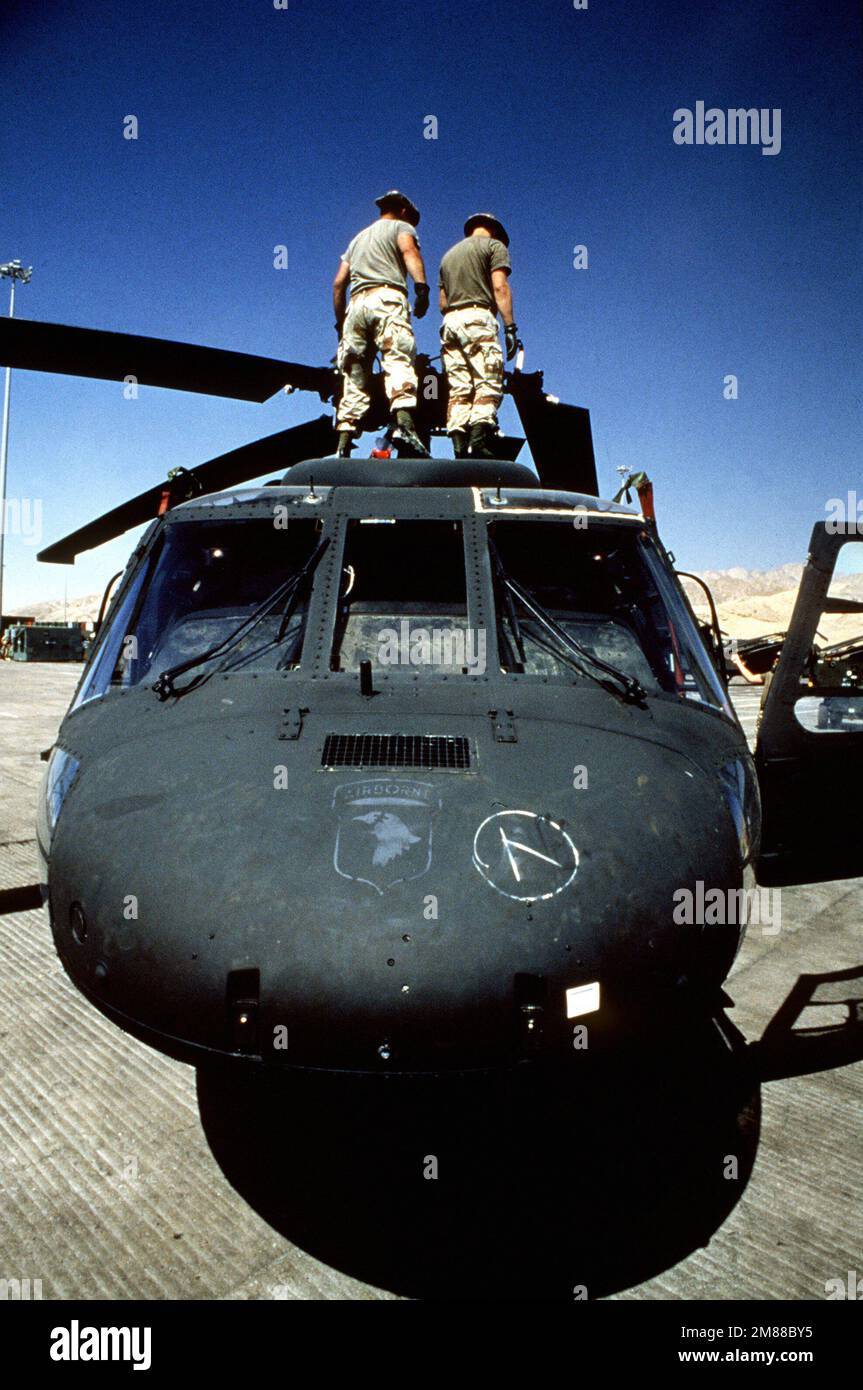 American servicemen examine the main rotor of a UH-60 Black Hawk ...