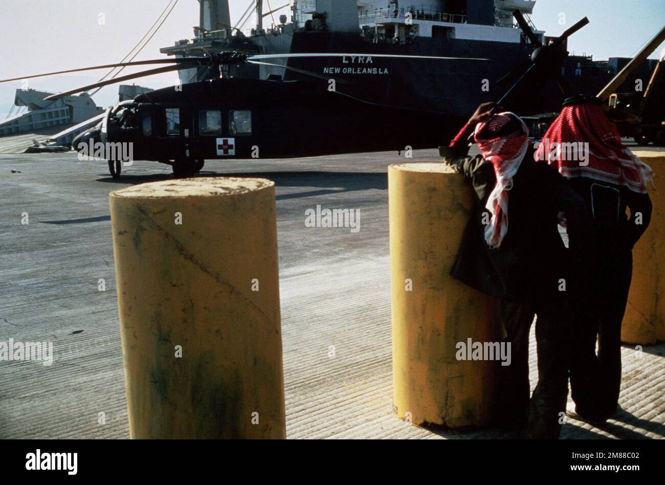 Jordanian dock workers look at a UH-60 Black Hawk helicopter which has ...